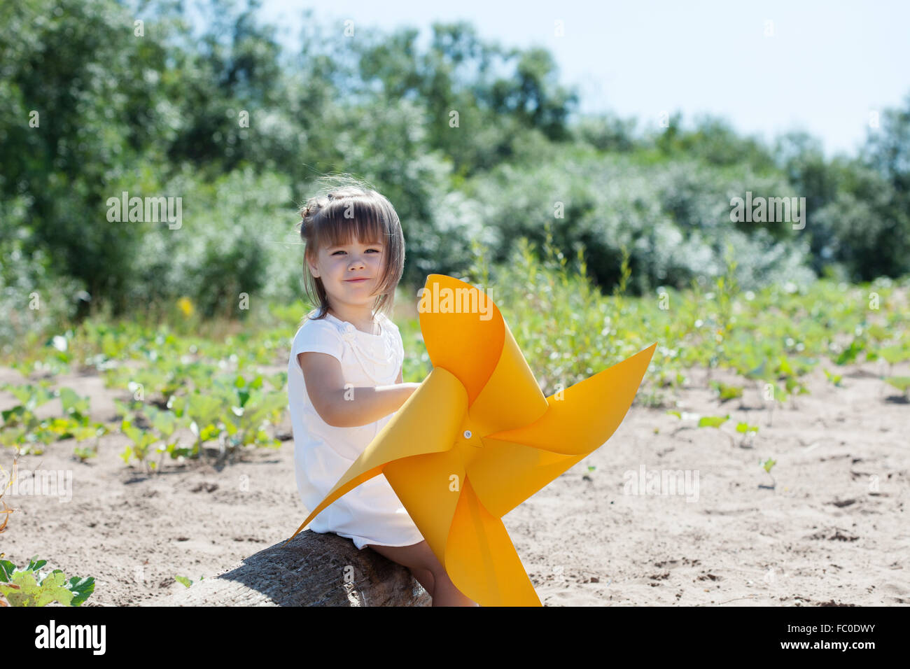 Smiling little girl playing with windmill Stock Photo - Alamy
