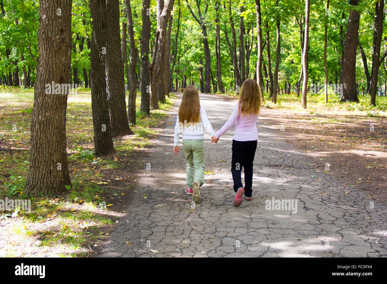 Cute two girls walking in park Stock Photo - Alamy
