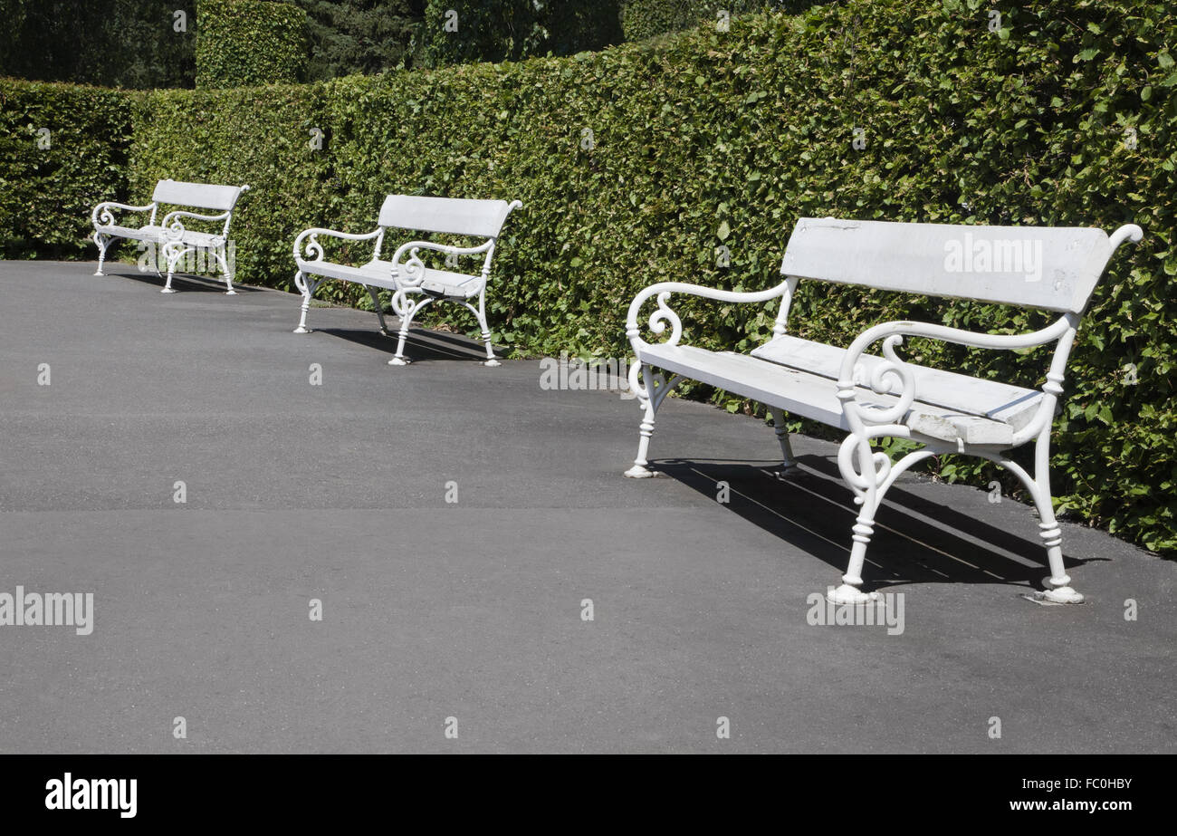 Row of white benches in a park Stock Photo - Alamy