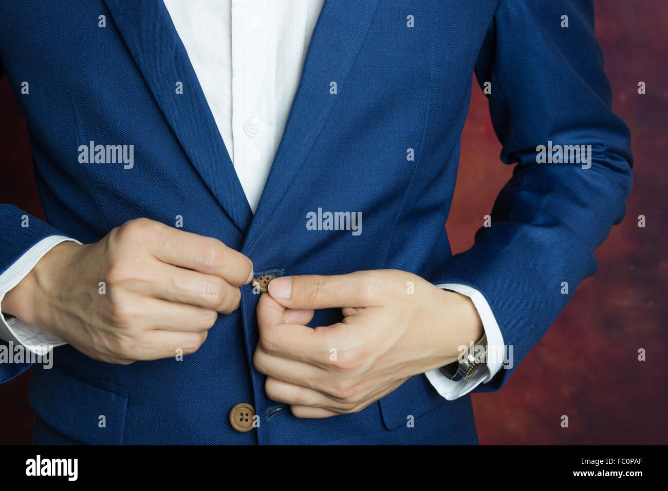 Man in blue suit two bottons, doing button Stock Photo - Alamy