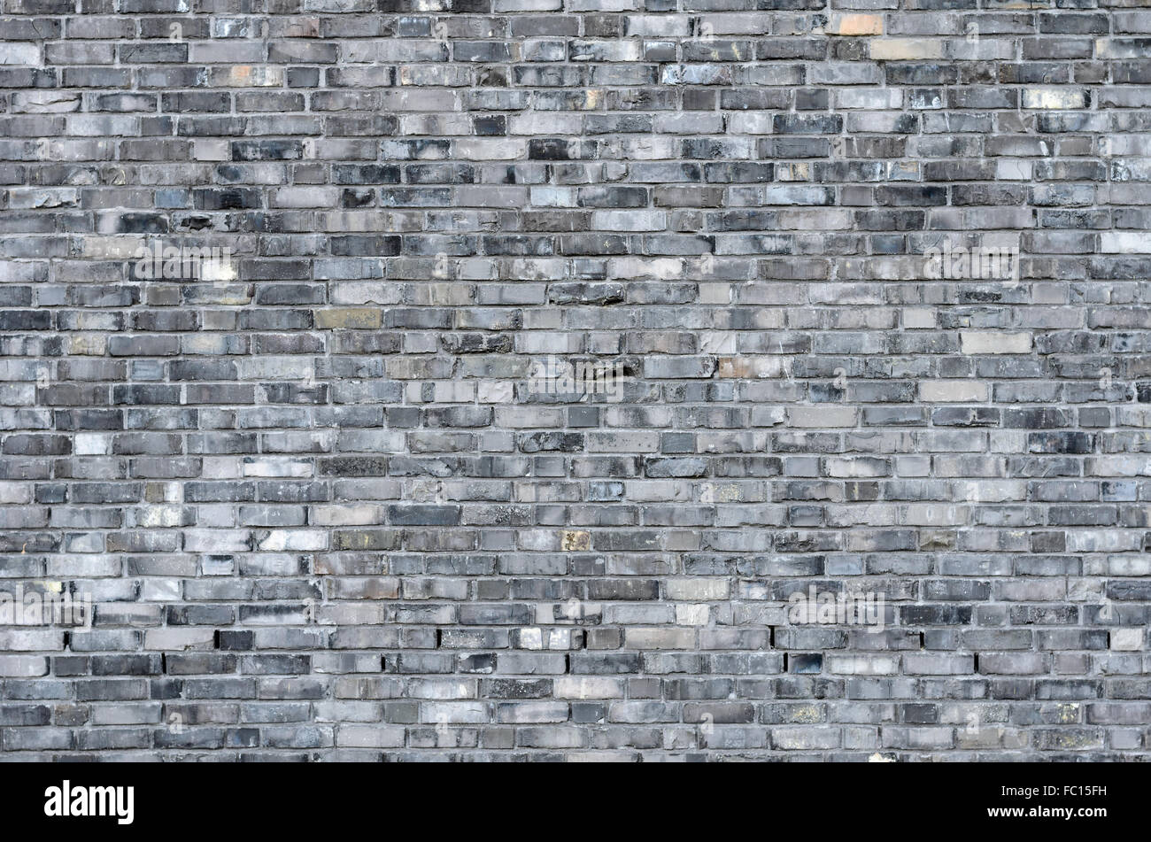 Repeating grey color brick wall background with mottled appearance for ...