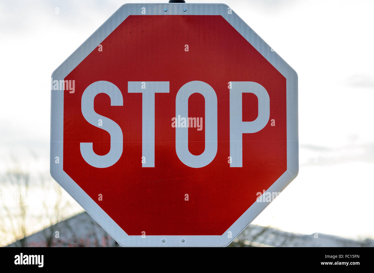 Close up of red and white stop sign in front of obscure building ...