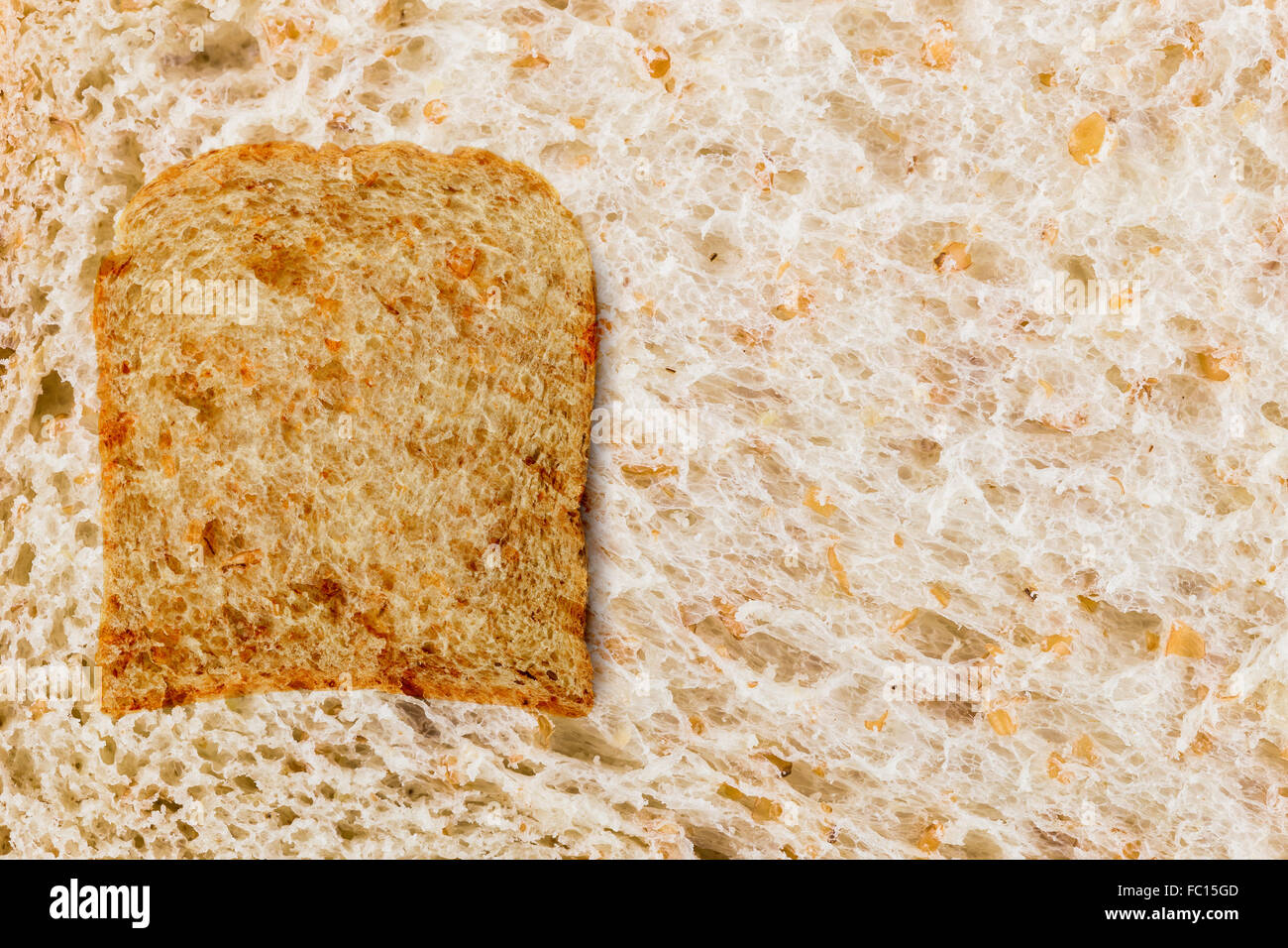 Background of brown whole wheat bread's surface with a piece of bread ...