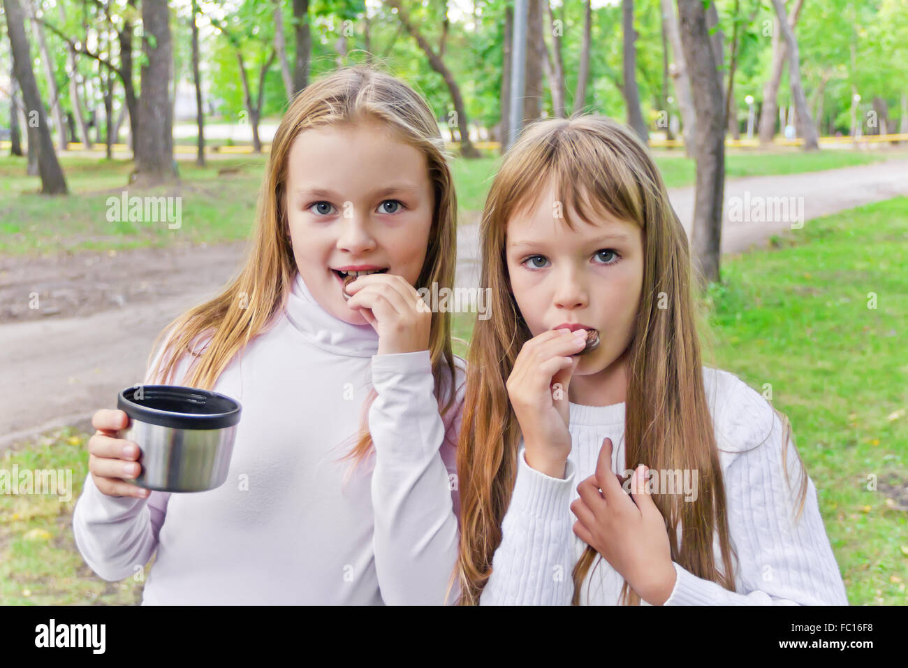 Cute two eating girls Stock Photo - Alamy