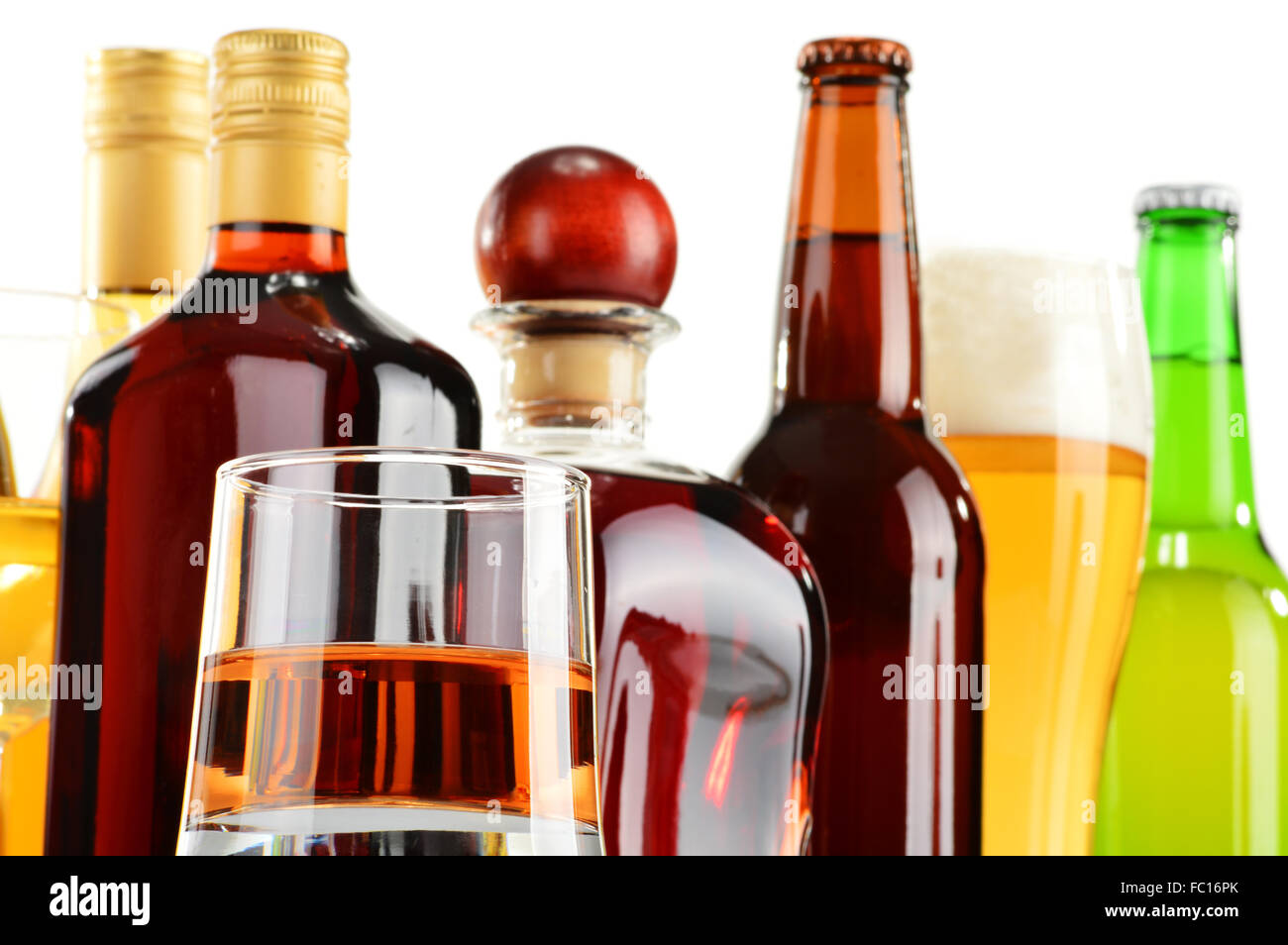 Bottles and glasses of assorted alcoholic beverages over white ...