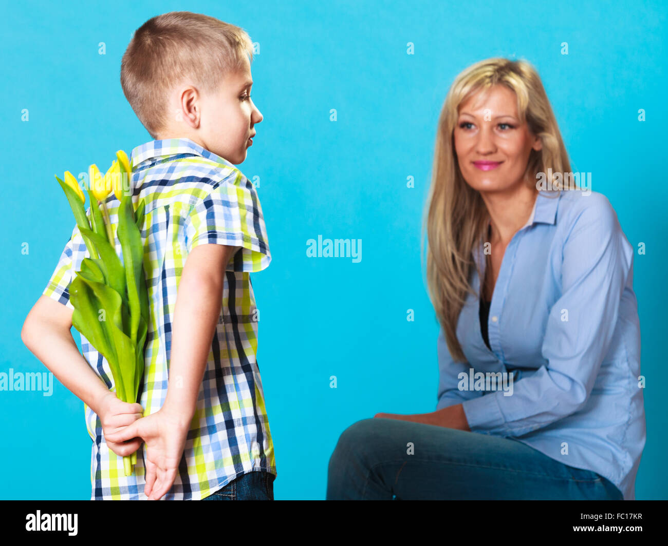 Boy holding flowers for mother hi-res stock photography and images - Alamy