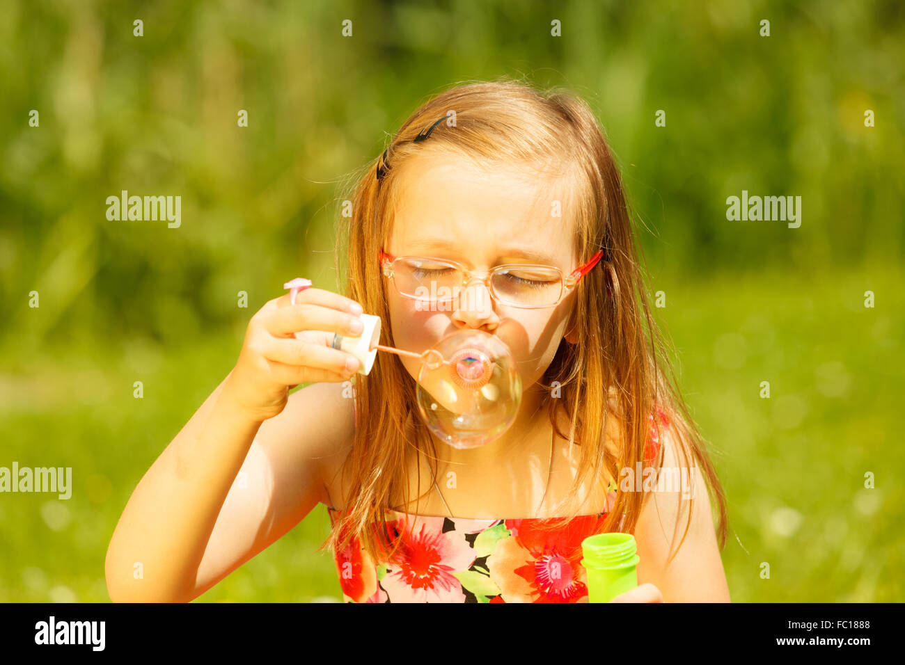 Little girl having fun blowing soap bubbles in park Stock Photo - Alamy