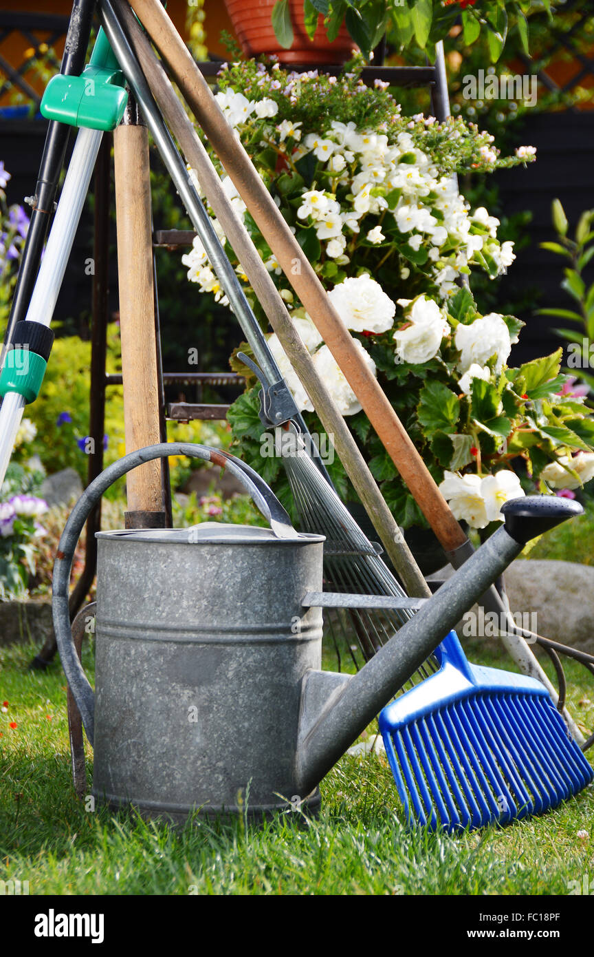 Watering can and tools in the garden Stock Photo - Alamy