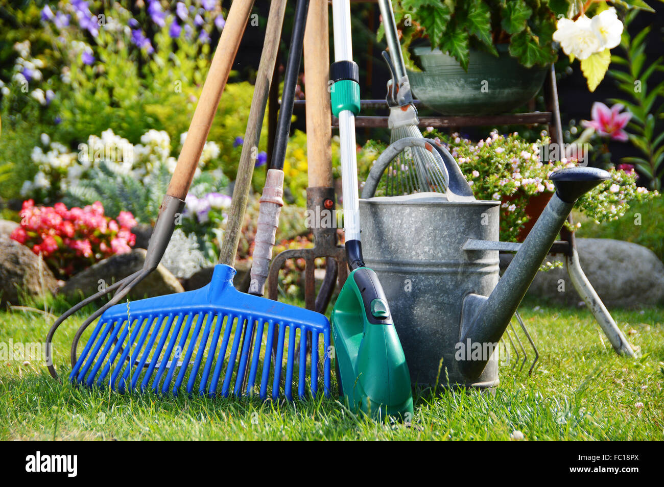 Watering can and tools in the garden Stock Photo - Alamy