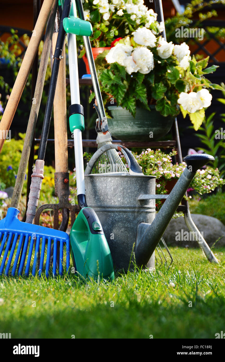 Watering can and tools in the garden Stock Photo - Alamy