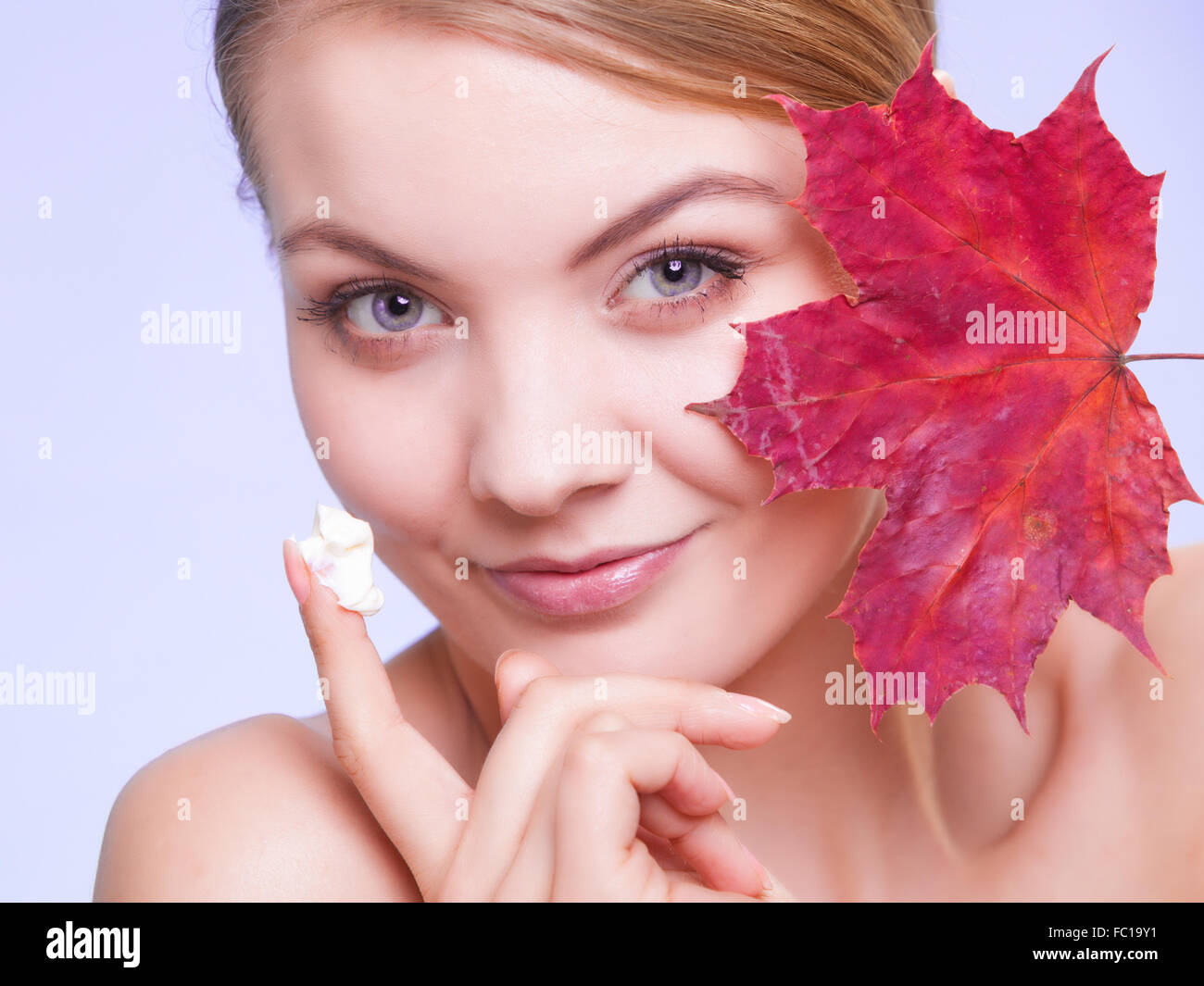 Skin care. Face of young woman girl with red maple leaf Stock Photo - Alamy