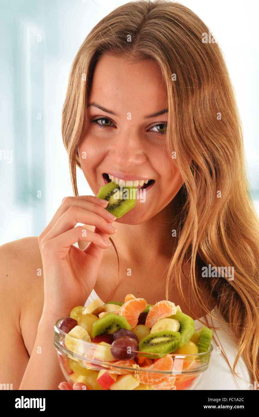 Young woman eating fruit salad Stock Photo - Alamy