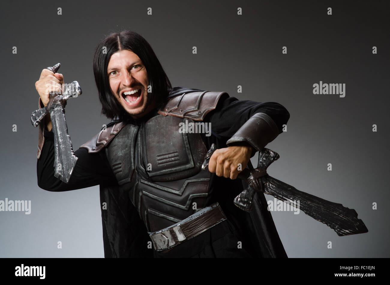Angry knight with sword against dark background Stock Photo - Alamy