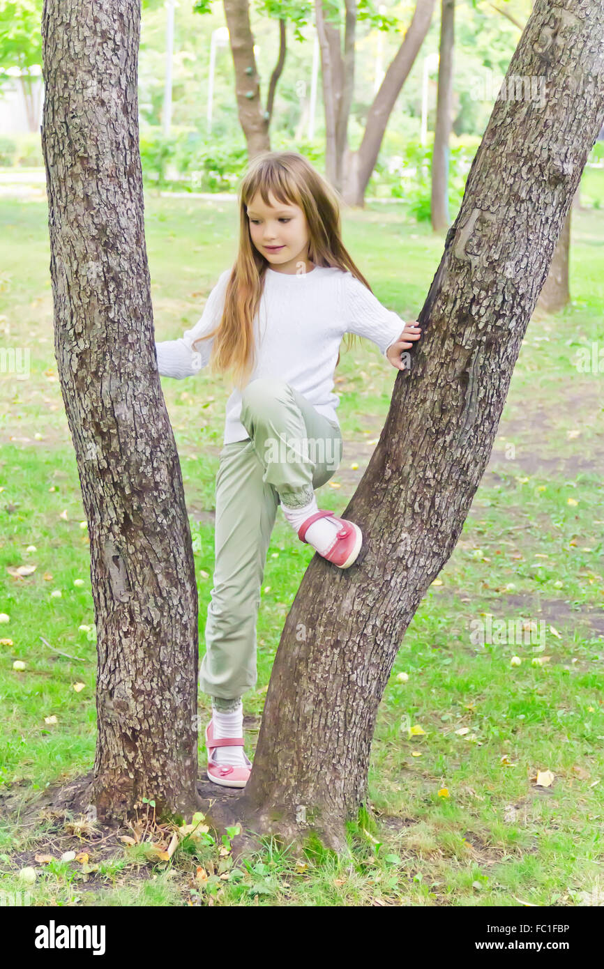 Cute girl in summer sit on tree Stock Photo - Alamy