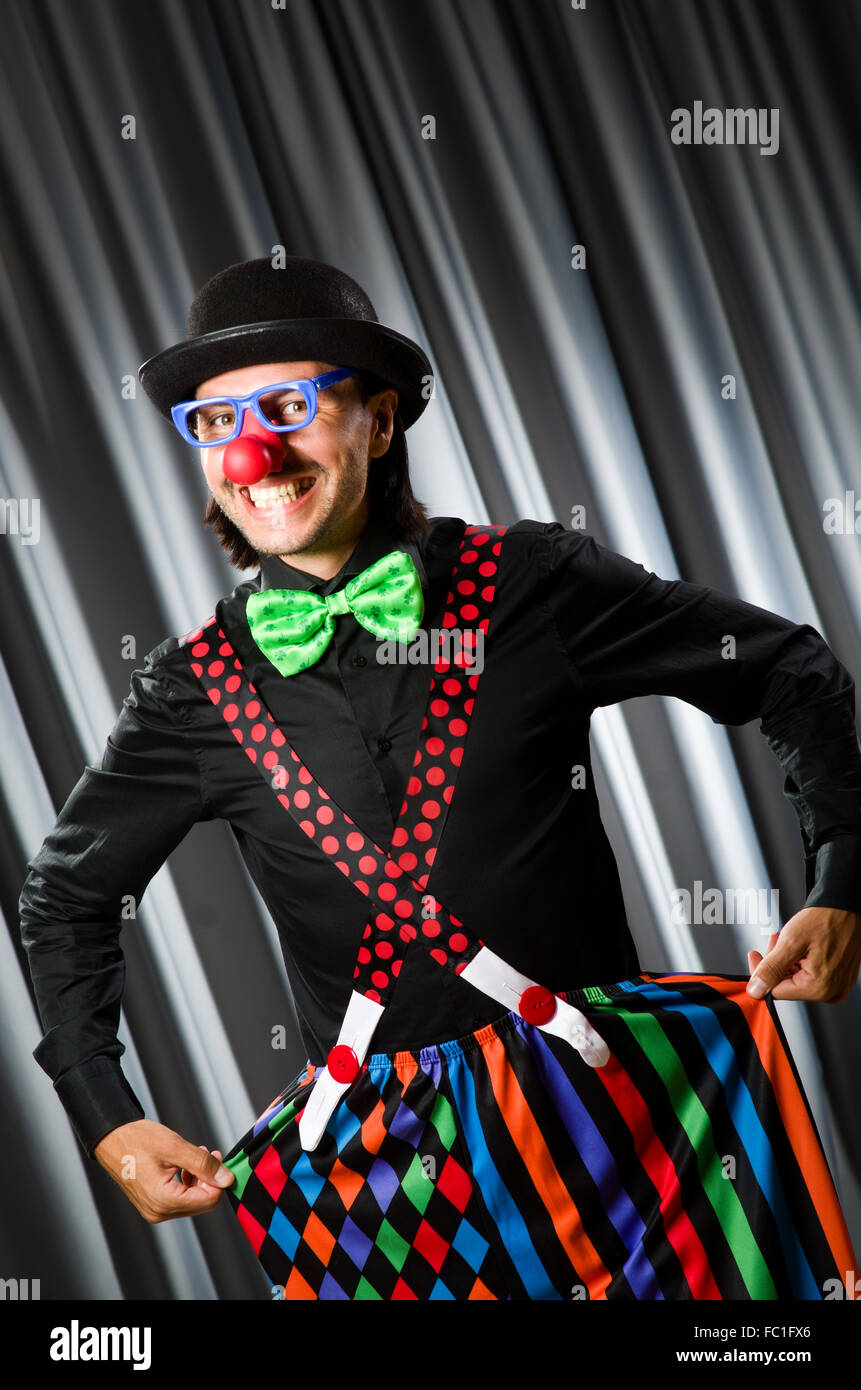 Funny clown in humorous concept against curtain Stock Photo - Alamy