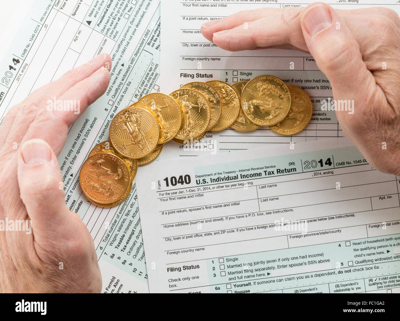 Solid gold coins on 2014 form 1040 Stock Photo - Alamy
