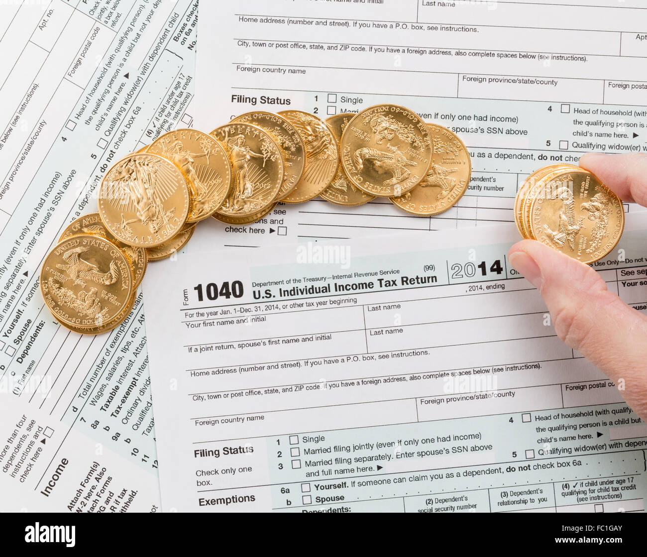 Solid gold coins on 2014 form 1040 Stock Photo - Alamy