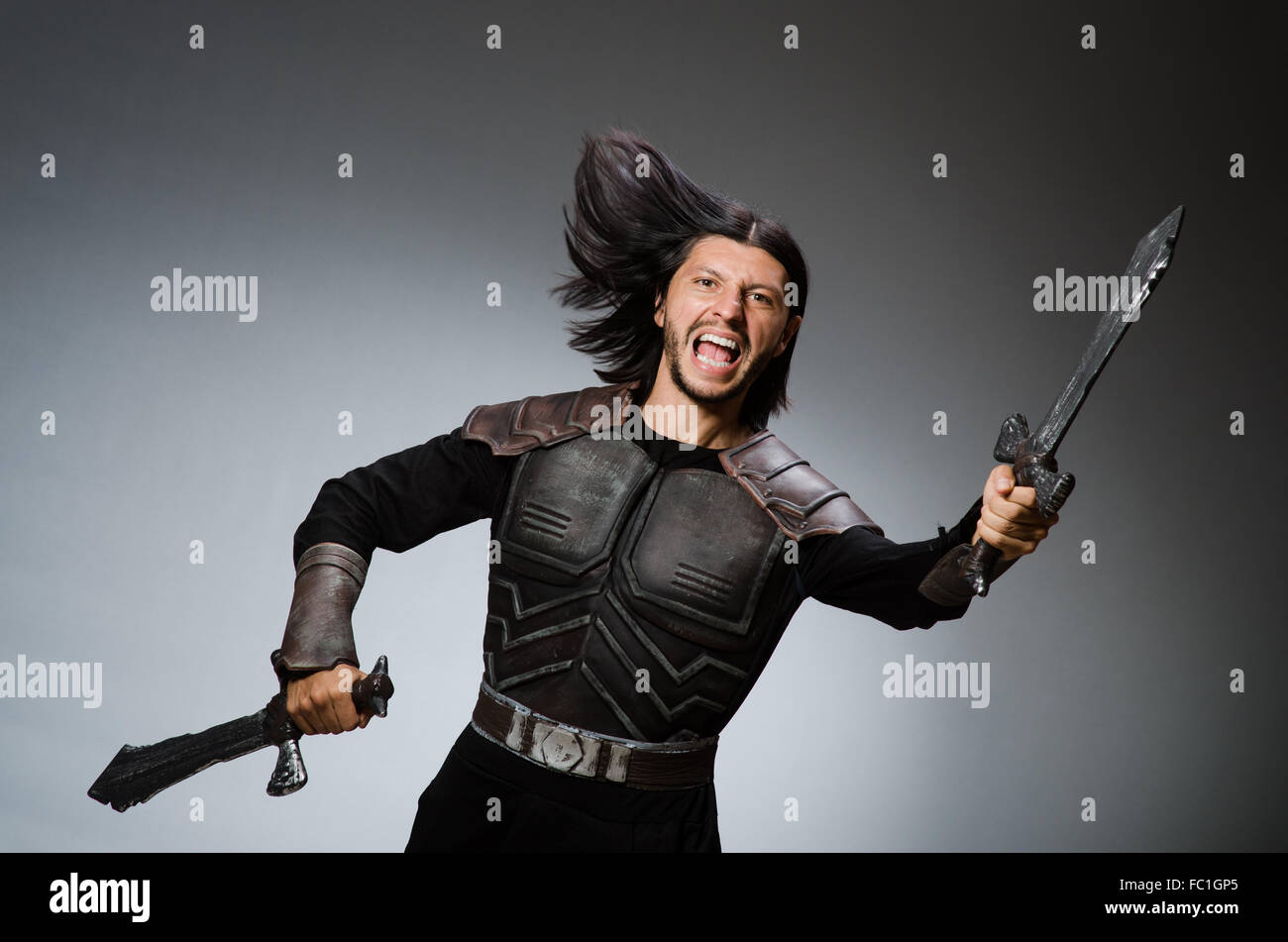 Angry knight with sword against dark background Stock Photo - Alamy