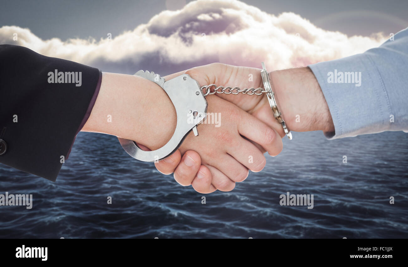 Composite image of business people in handcuffs shaking hands Stock ...