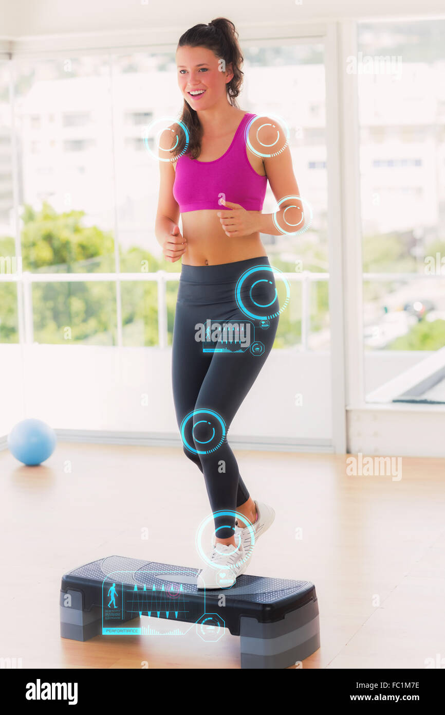 Composite image of full length of a fit woman performing step aerobics ...