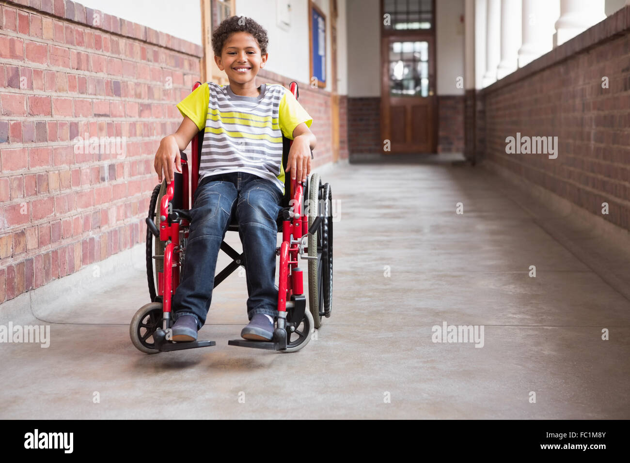Cute disabled pupil smiling at camera in hall Stock Photo - Alamy