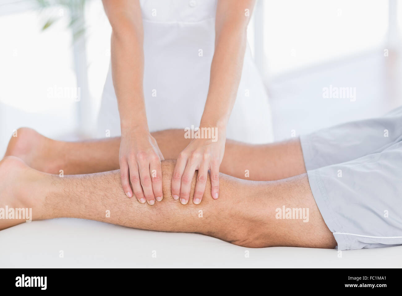 Physiotherapist doing calf massage to her patient Stock Photo - Alamy