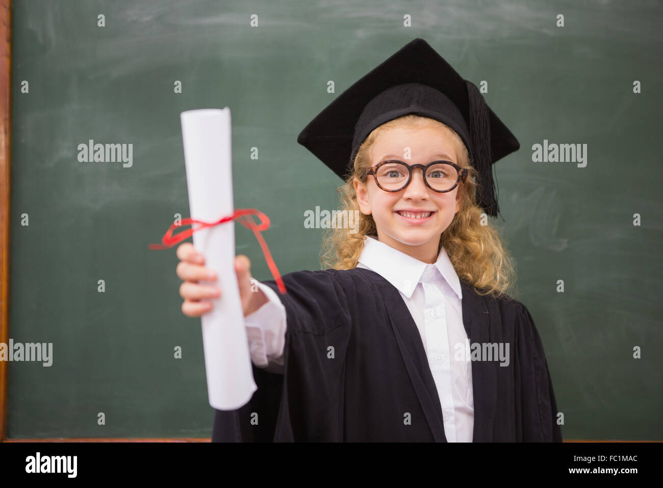 Pupil with graduation robe and holding her diploma Stock Photo - Alamy