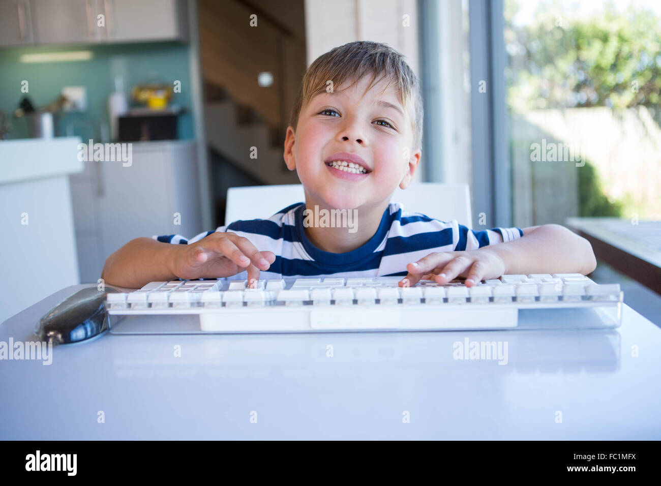 Little boy using computer in the living room Stock Photo - Alamy