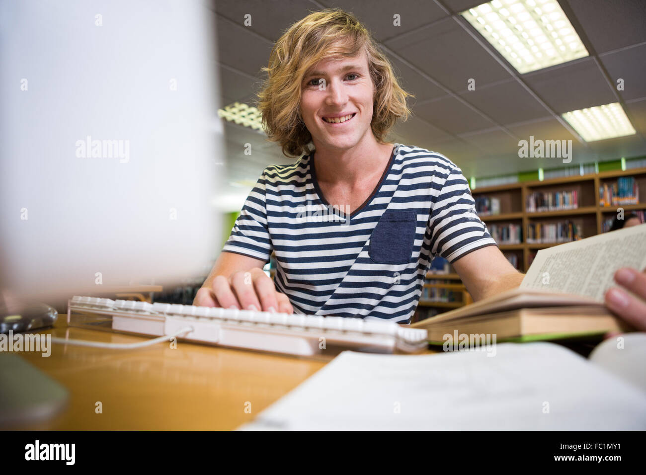 Student studying in the library with computer Stock Photo - Alamy