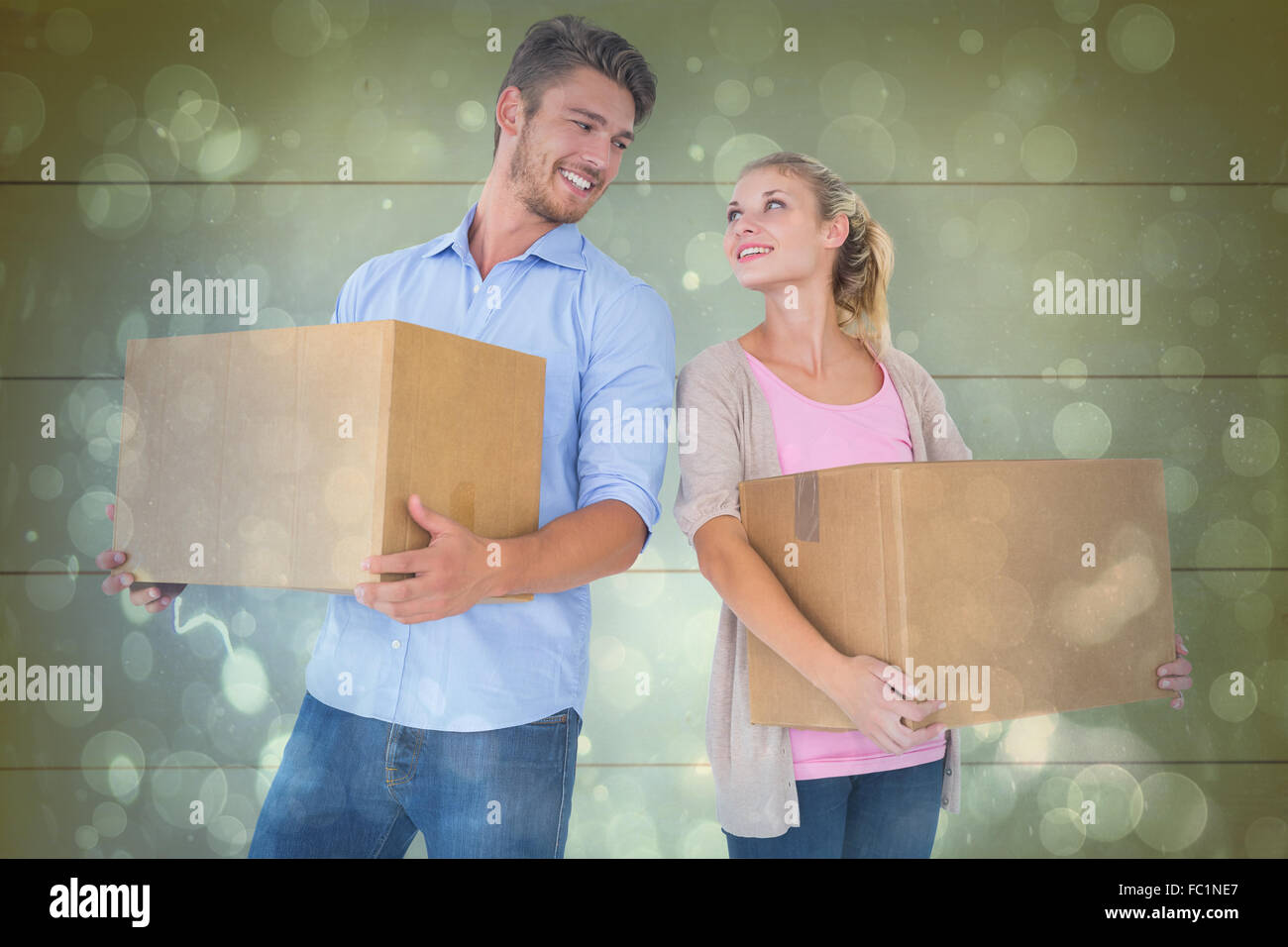 Composite image of attractive young couple carrying moving boxes Stock Photo - Alamy