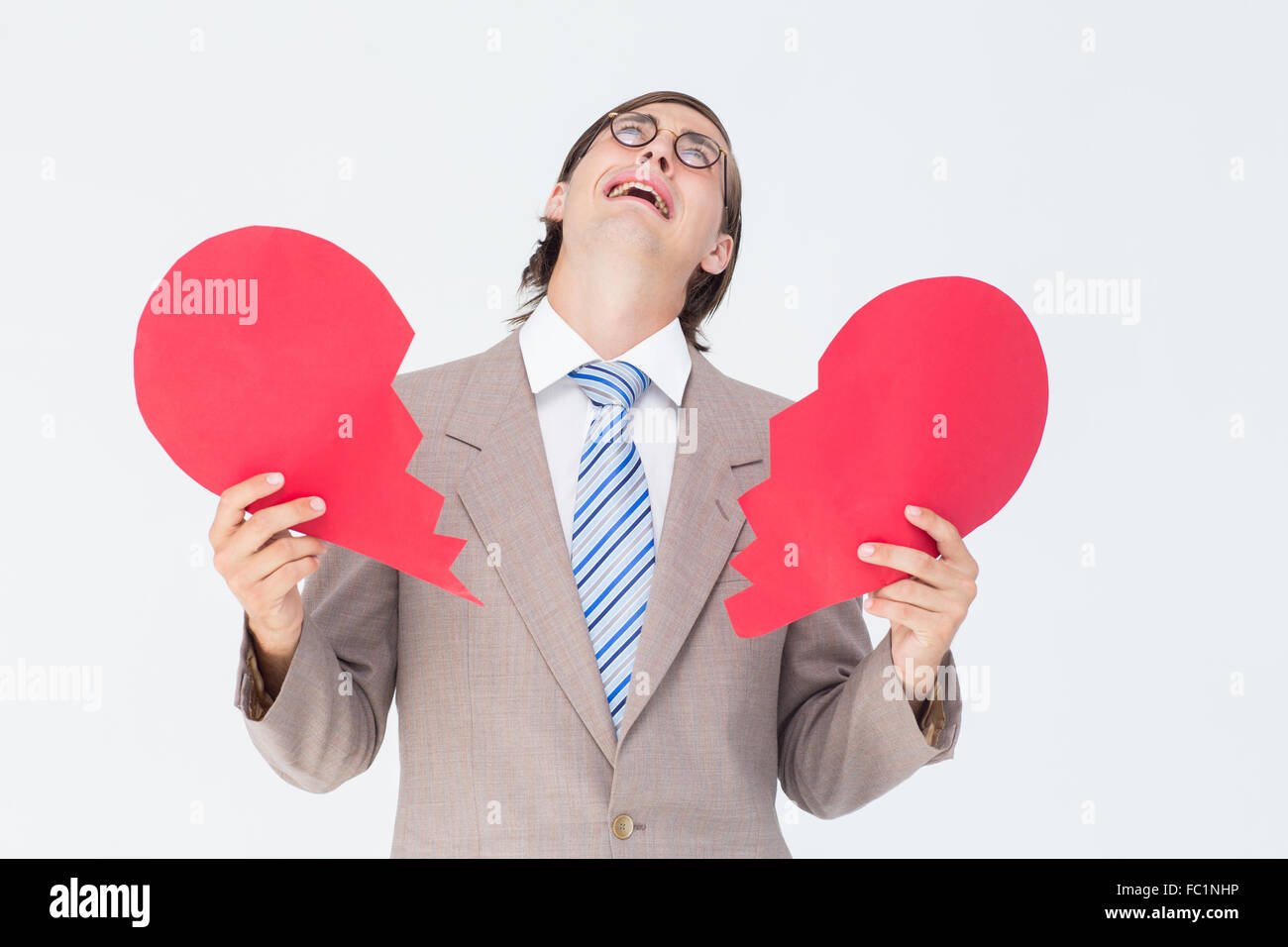 Geeky businessman crying and holding broken heart card Stock Photo - Alamy