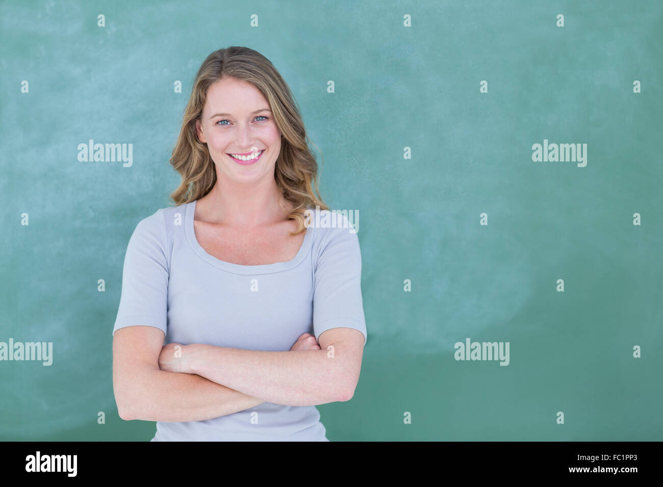 Smiling teacher standing in front of blackboard Stock Photo - Alamy