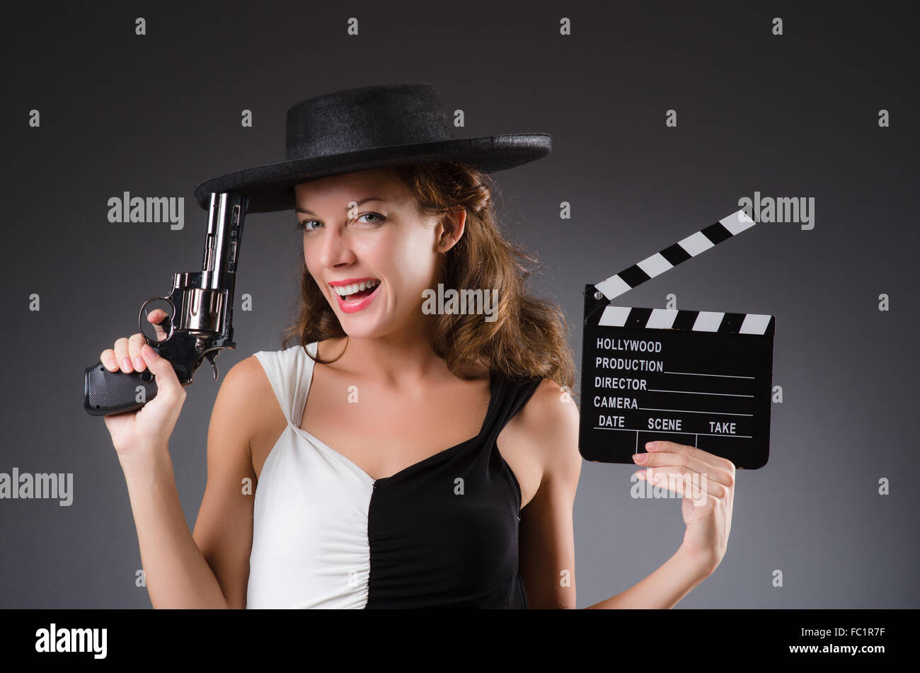 Girl with gun and clapperboard isolated on white Stock Photo - Alamy