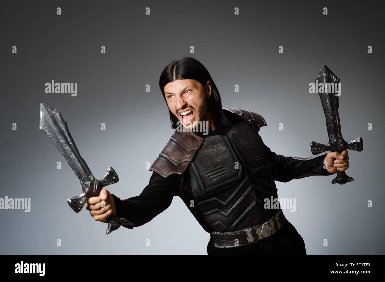 Angry knight with sword against dark background Stock Photo - Alamy
