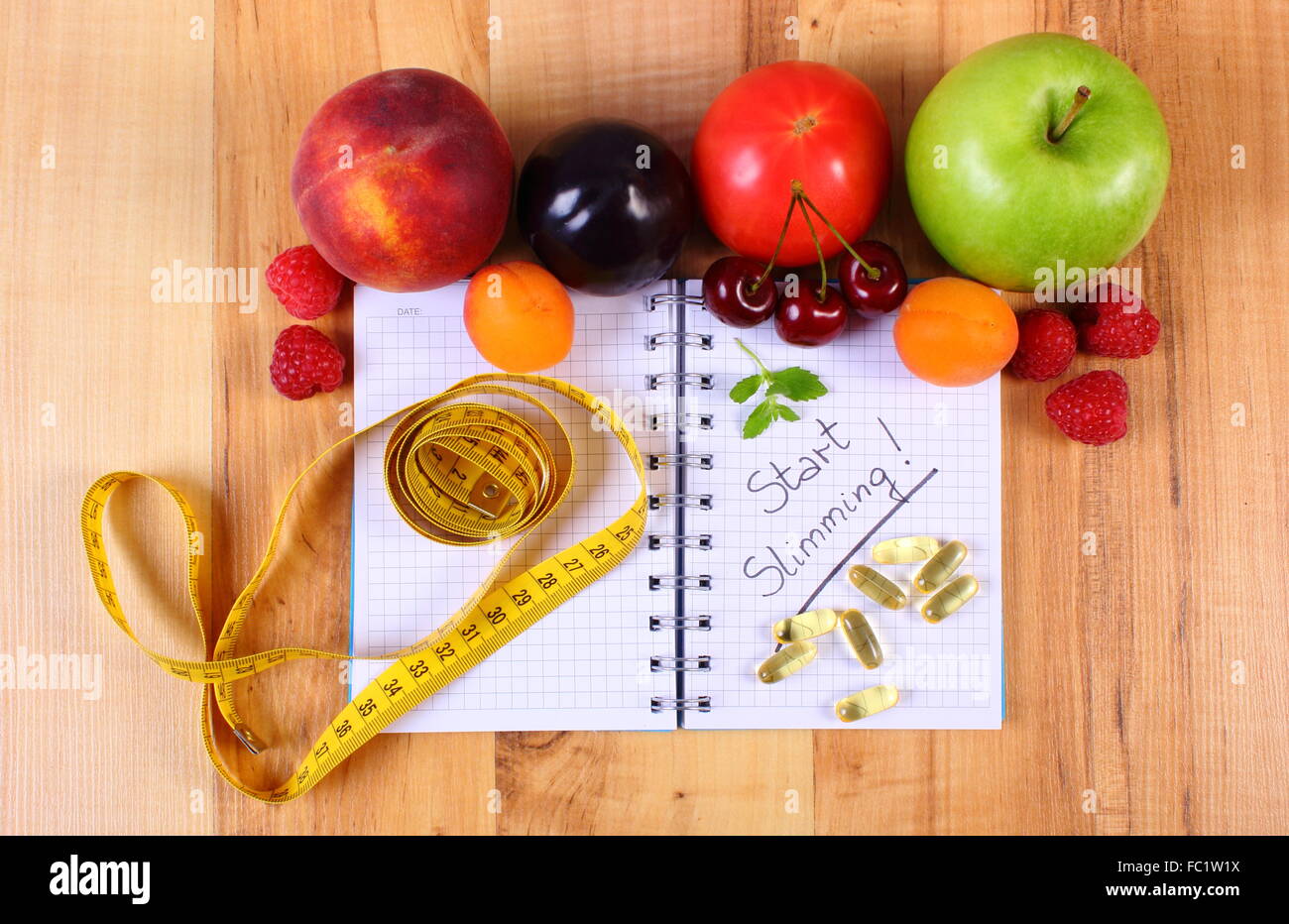 Fresh fruits, vegetables, tape measure and tablets supplements with ...