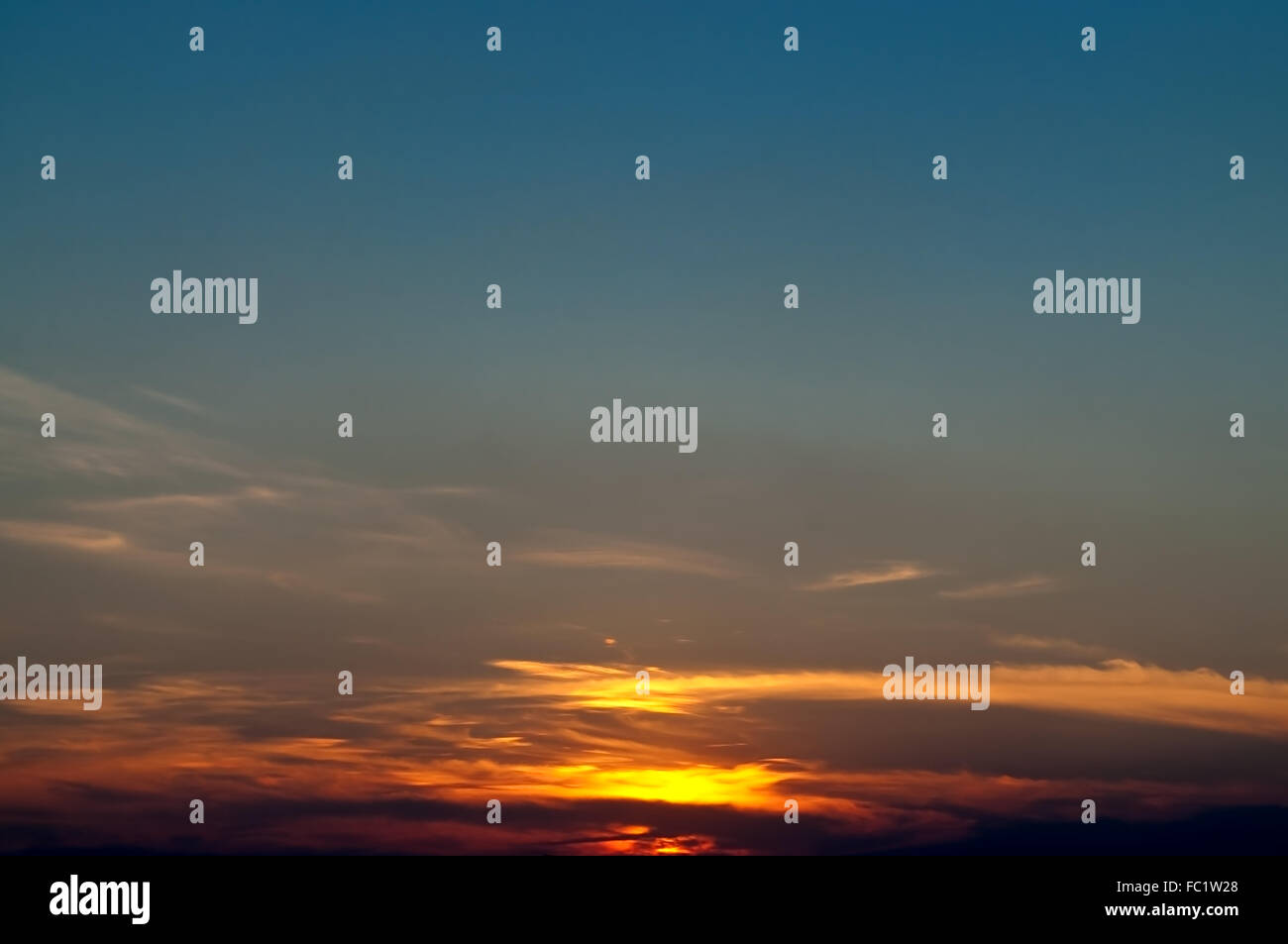 The sun already set below the thin layer of clouds reflecting bright ...