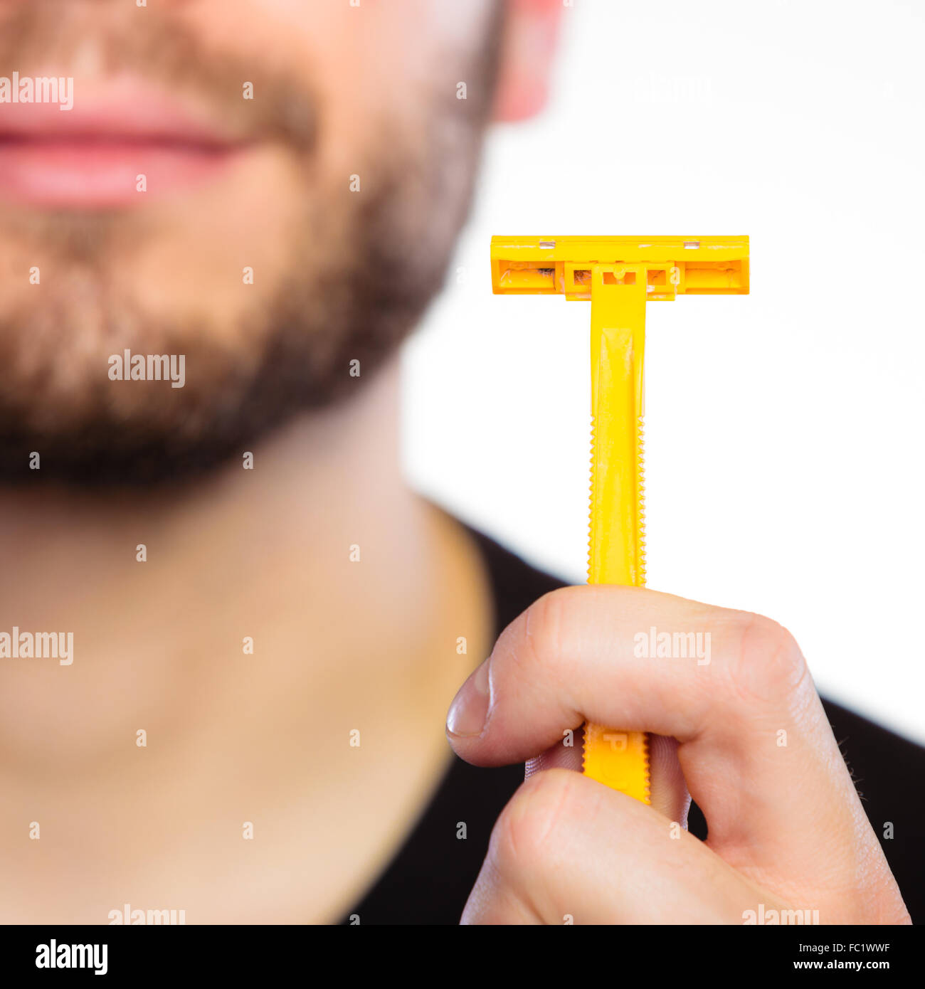 Young man with beard showing razor blade Stock Photo - Alamy