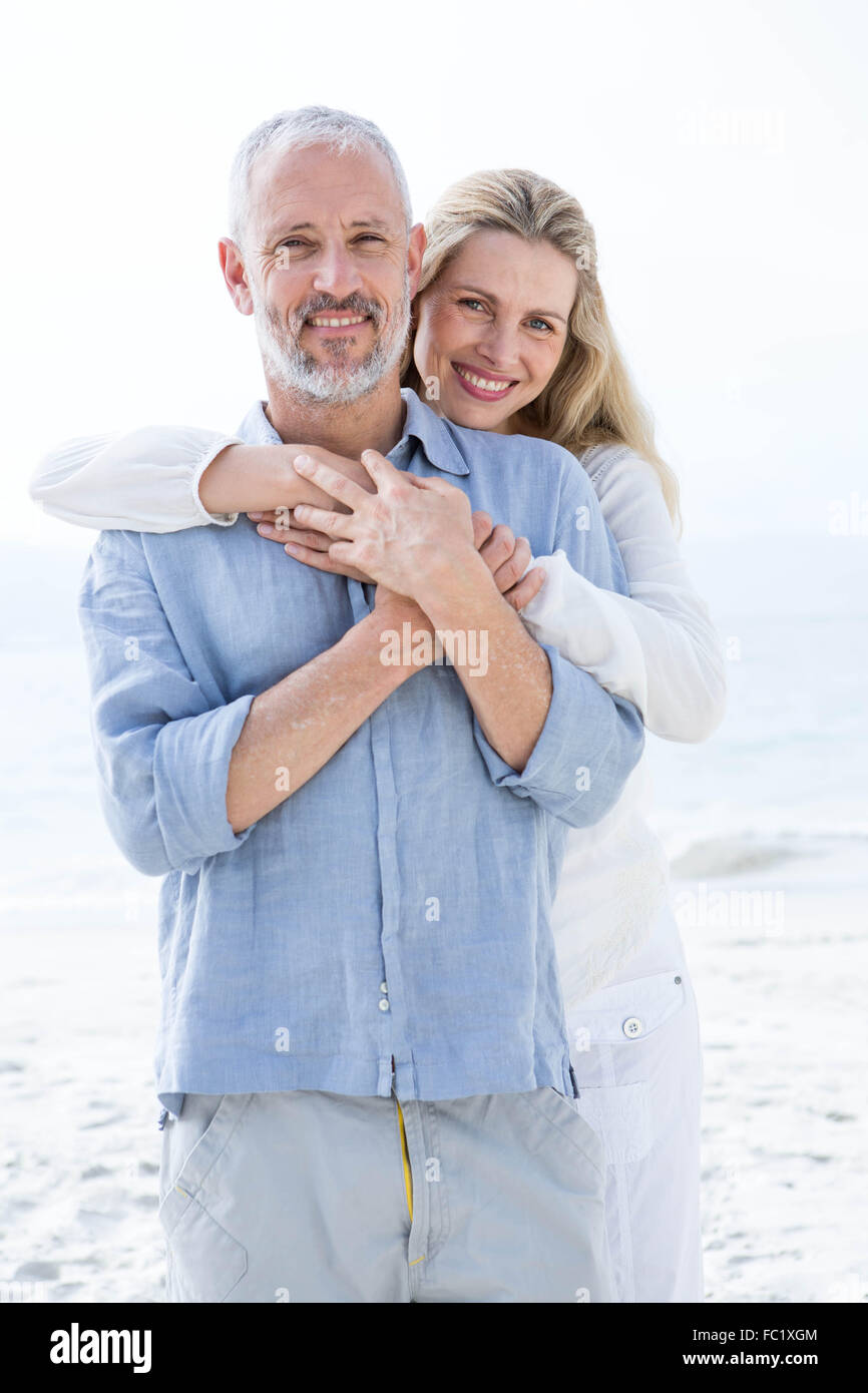 Happy couple hugging each other and looking at camera Stock Photo - Alamy