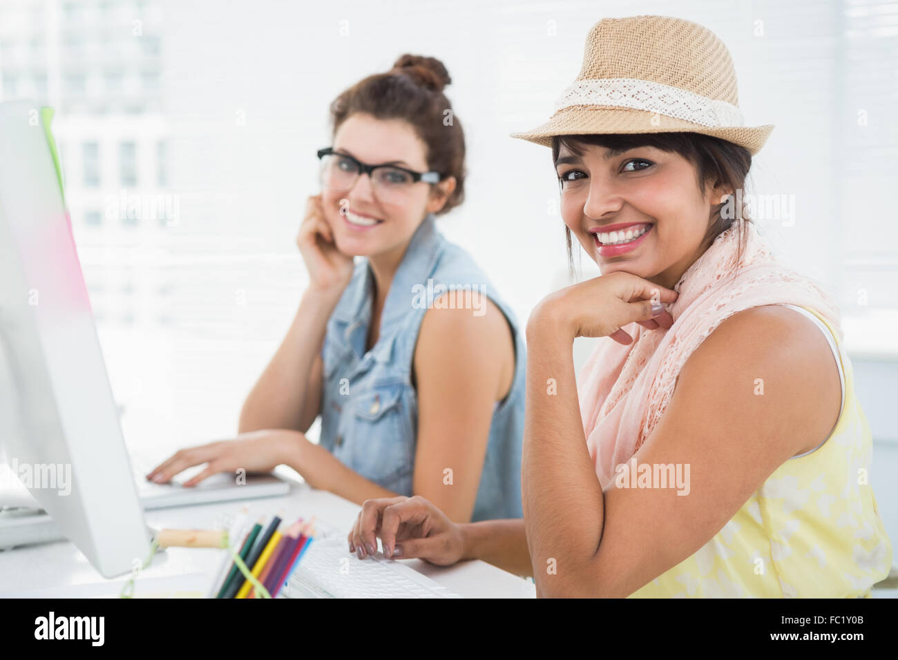 Portrait of smiling colleagues sitting and posing Stock Photo - Alamy