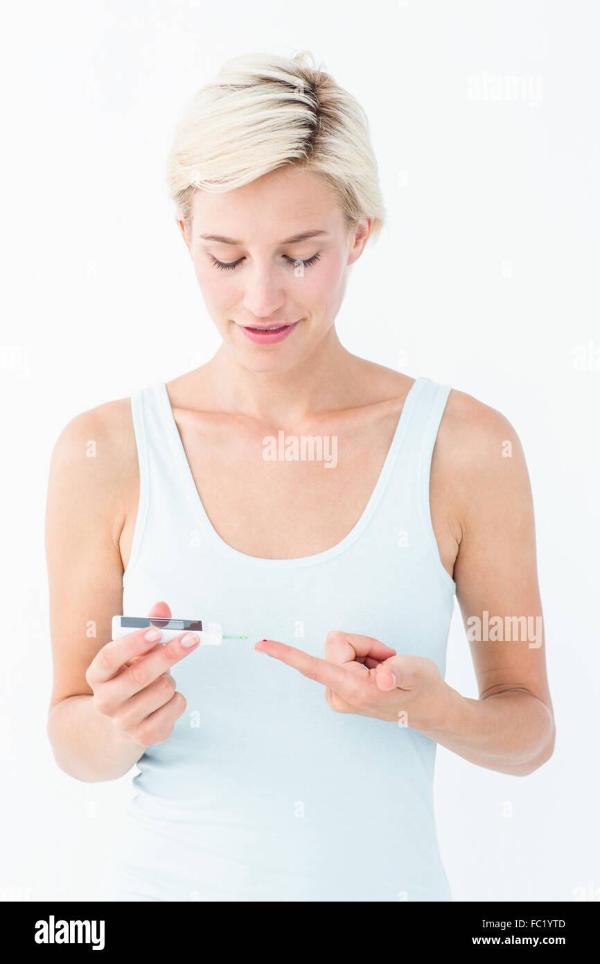 Pretty blonde testing her blood glucose level Stock Photo - Alamy