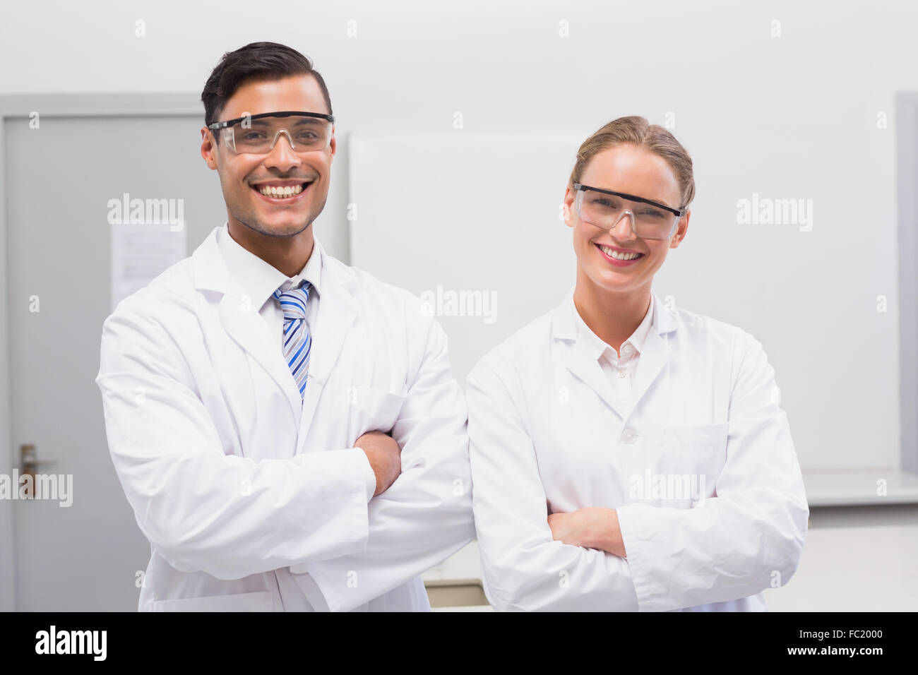 Smiling scientists looking at camera arms crossed Stock Photo - Alamy