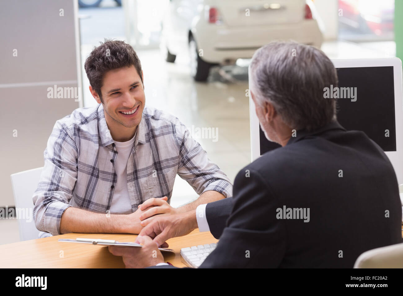 Salesman showing client where to sign the deal Stock Photo - Alamy