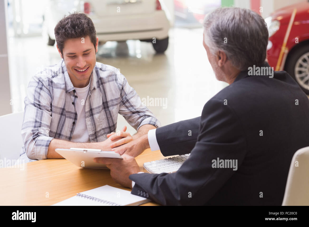 Salesman showing client where to sign the deal Stock Photo - Alamy