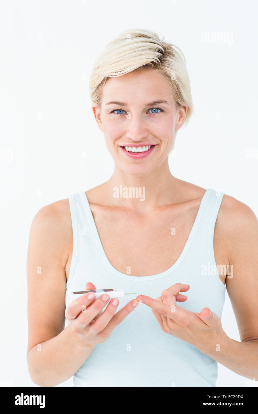 Pretty blonde testing her blood glucose level Stock Photo - Alamy