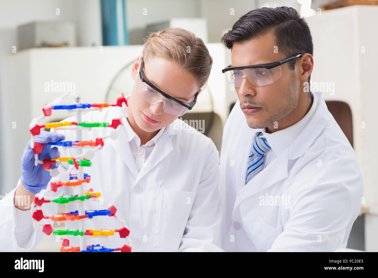 Concentrated scientists working together with dna helix Stock Photo - Alamy