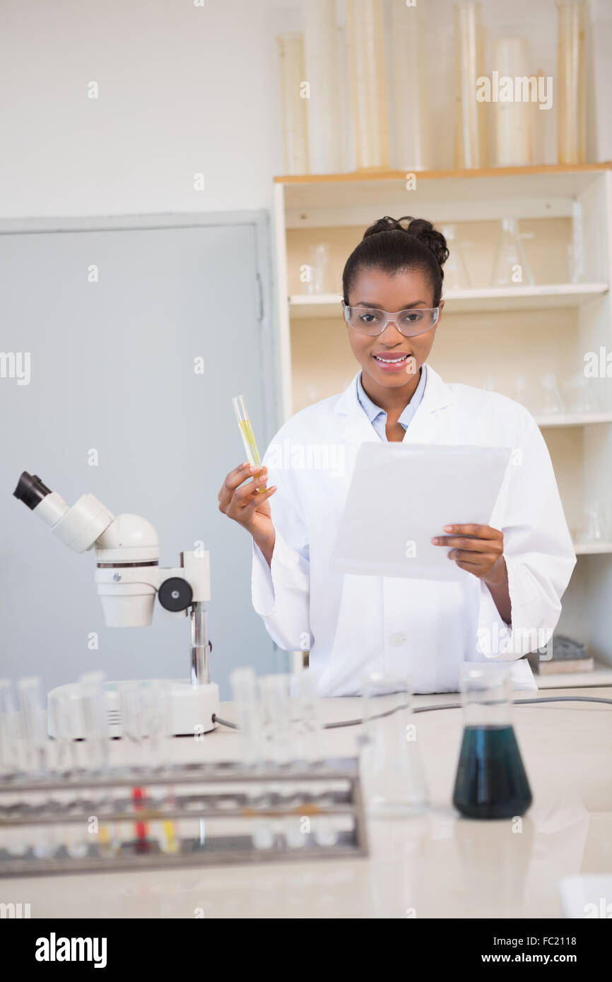 Smiling scientist looking at camera and holding paper Stock Photo - Alamy