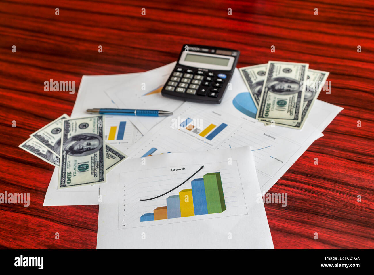 Bunch of printed charts and graphs with dollar bills, calculator and ...