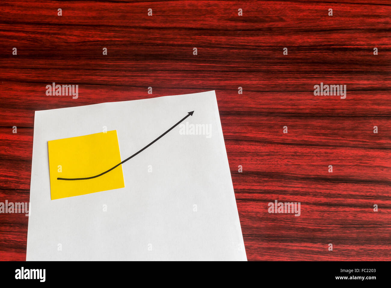 Sheet of paper with a yellow sticky note. A curve graph printed on both ...