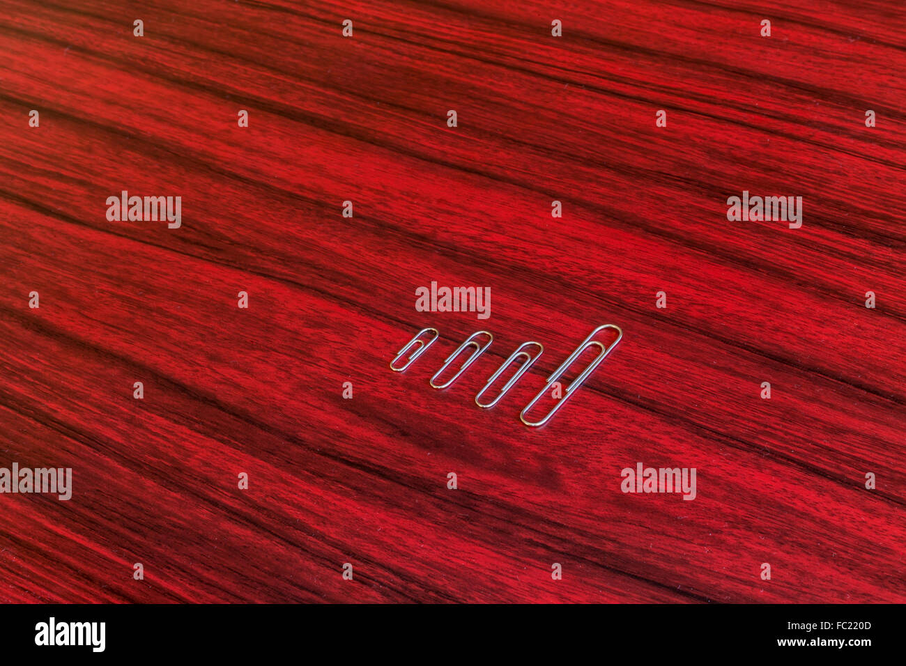 Paper clips arranged by size on a desk Stock Photo - Alamy