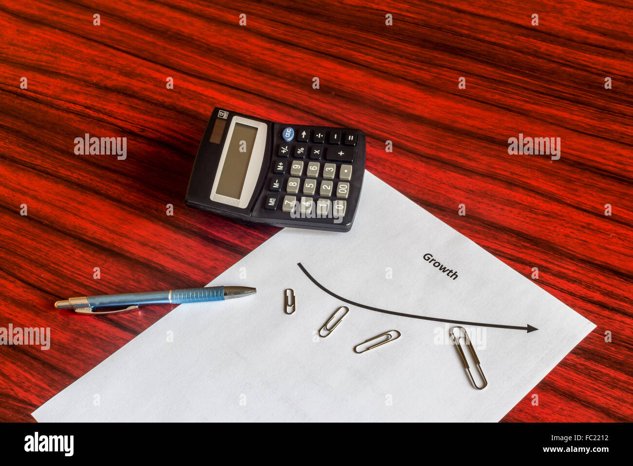 Different sized Paper clips arranged around a curve graph symbolising ...